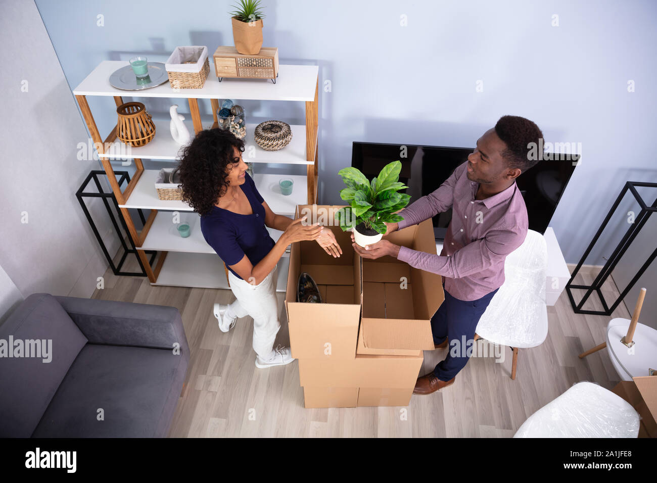 Couple Unpacking Boxes In Living Room In Their New Home Stock Photo - Alamy