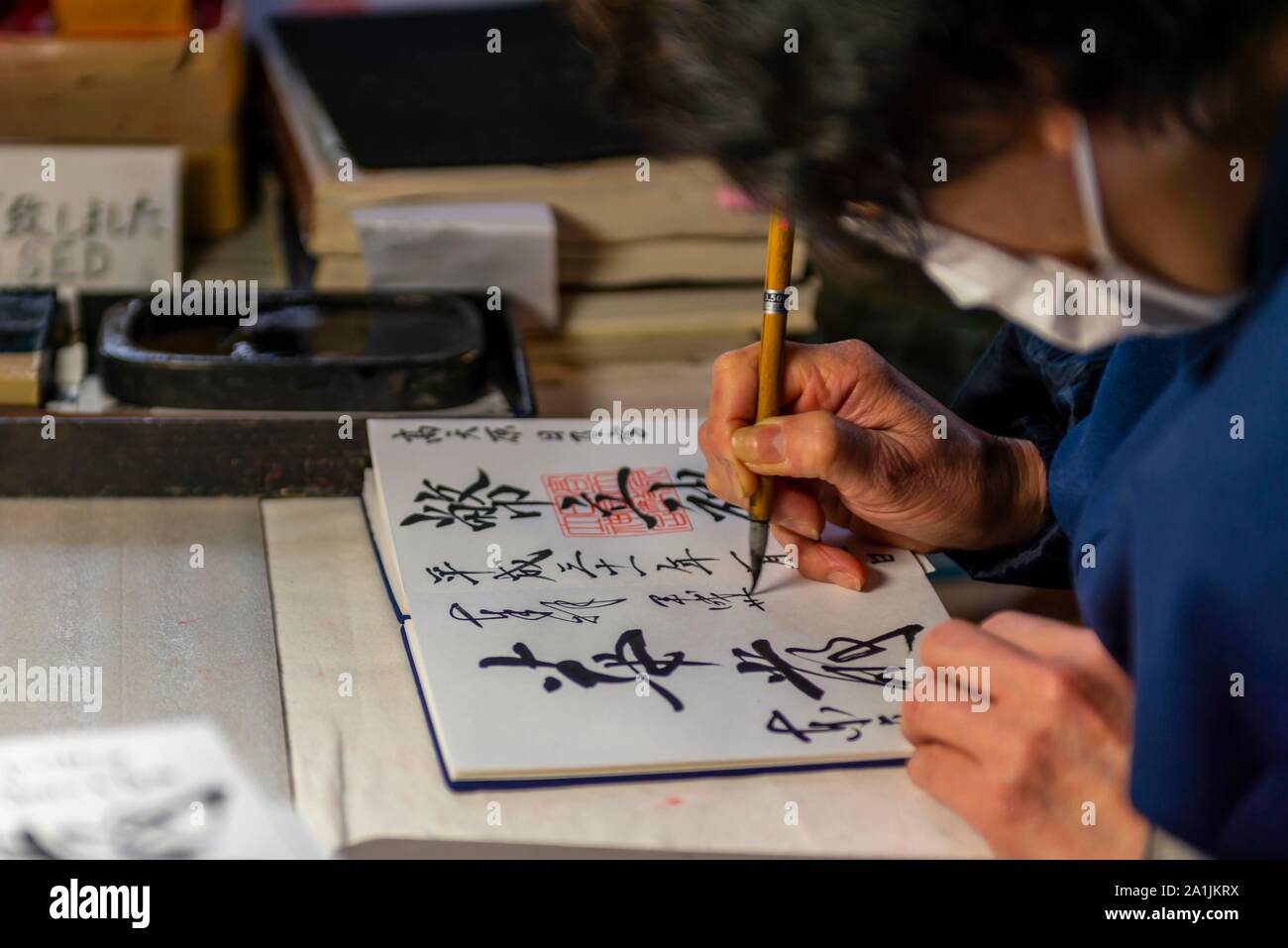 Woman writes Japanese characters, calligraphy, lucky charms to buy in ...