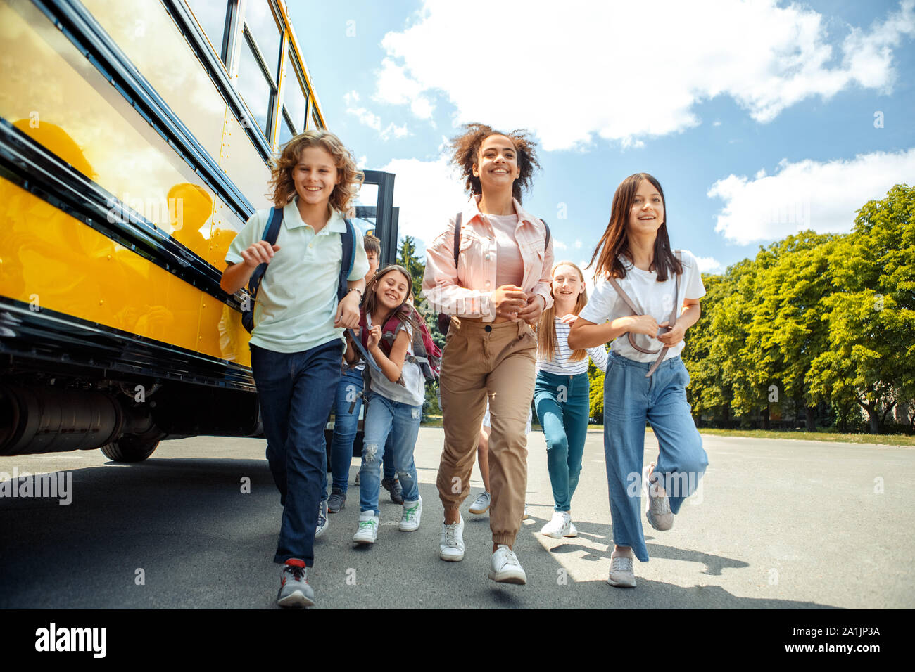 Group of children classmates running from school bus going back home ...