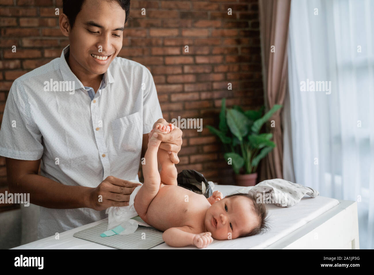 asian father change baby diapers Stock Photo - Alamy