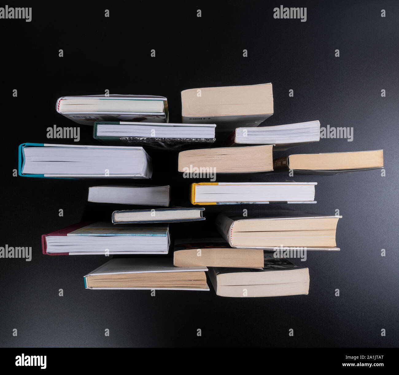 a series of books on a black surface seen from above Stock Photo - Alamy