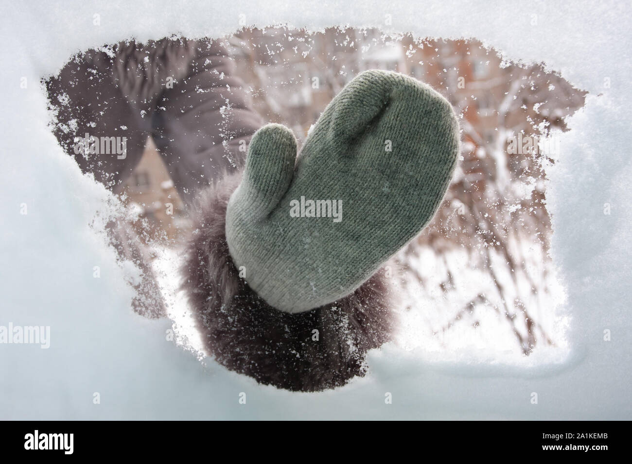 hand in mitten cleaning window of car from the snow, inside view Stock ...