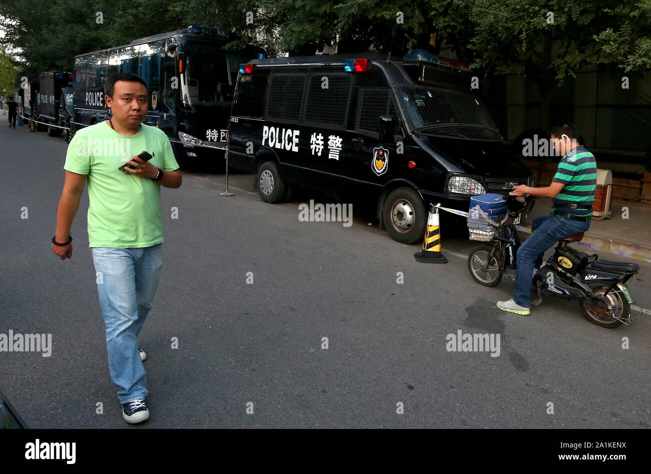 Beijing, China. 27th Sep, 2019. Chinese walk past a row of anti-riot ...