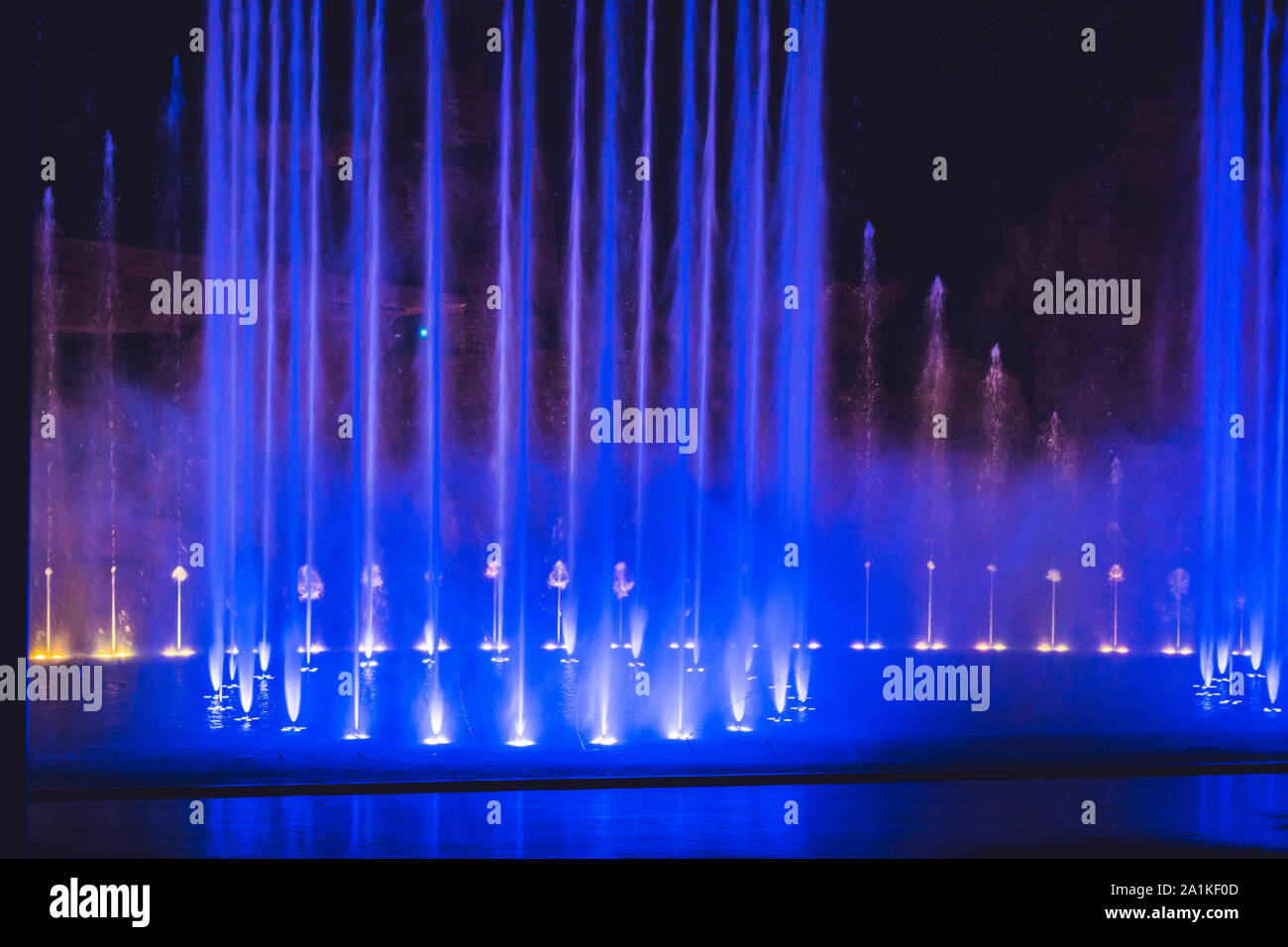 Multicolored dancing water jet fountain in the dark Stock Photo - Alamy