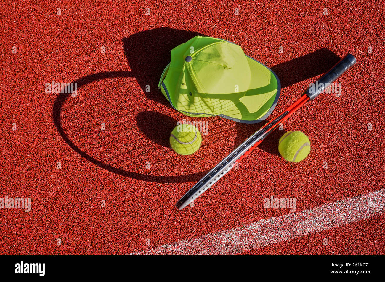 Tennis racket standing on end casting a shadow over an all weather ...