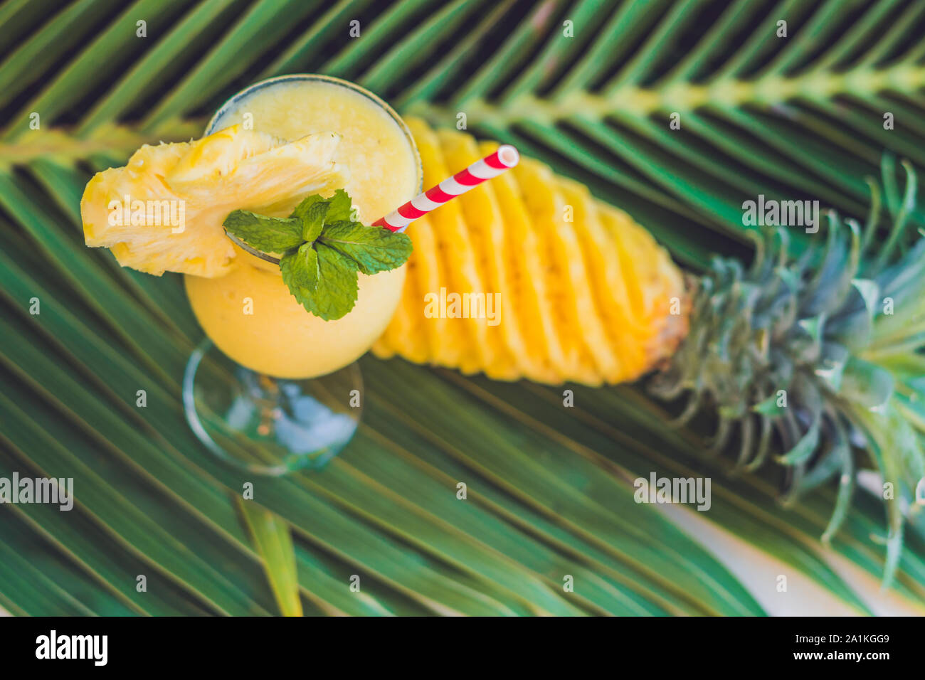 Pineapple and pineapple smoothies against the background of a branch of ...