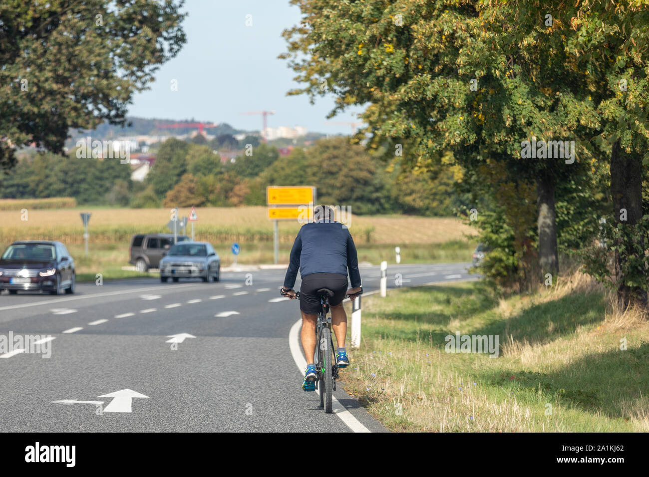 Cyclist rides on the highway on a bicycle Stock Photo - Alamy