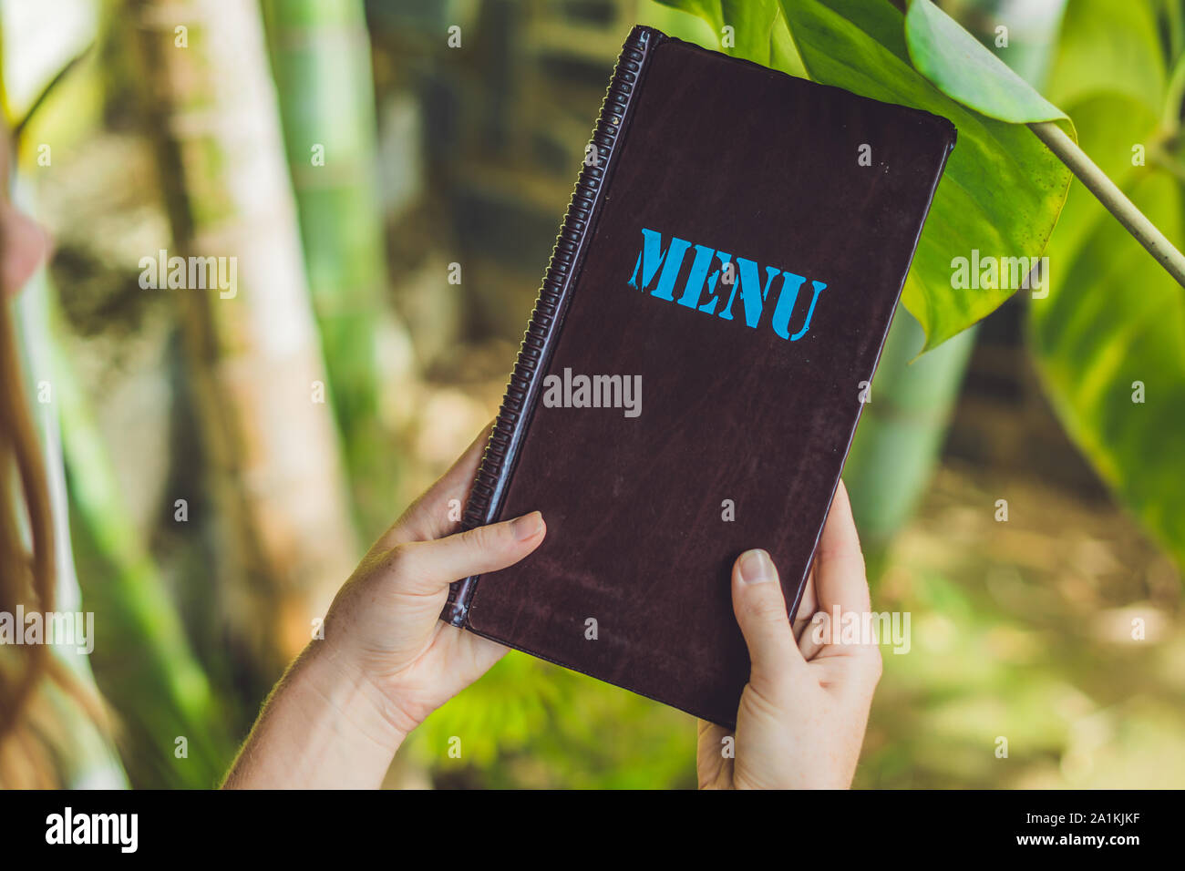 Beautiful woman ordering from menu in restaurant and deciding what to ...