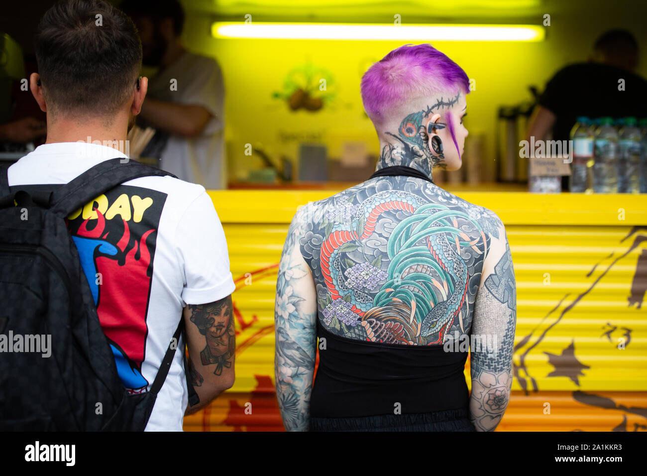 A heavily tattooed women stands in a food store queue during the ...