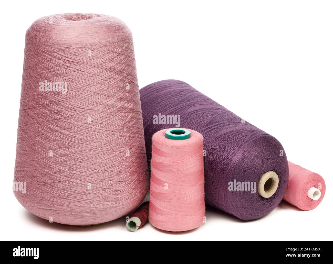 Group of cones and spools of pink and violet synthetic or cotton ...