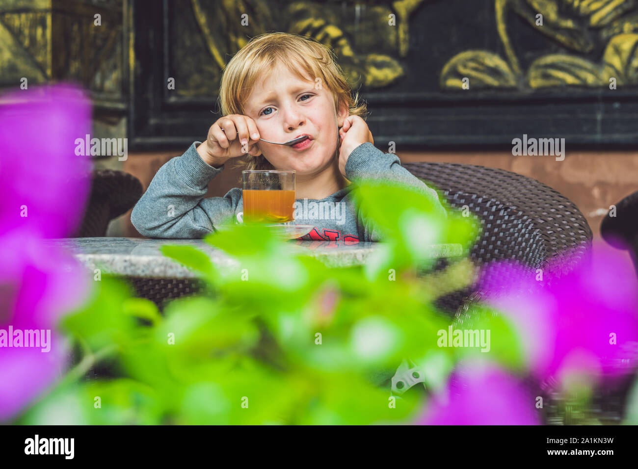 Cute little boy drinking tea in cafeteria Stock Photo - Alamy