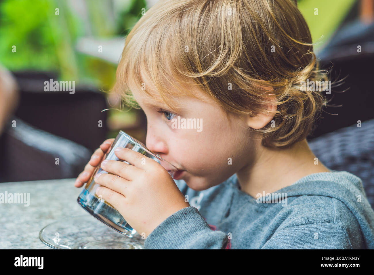 Cute little boy drinking tea in cafeteria Stock Photo - Alamy