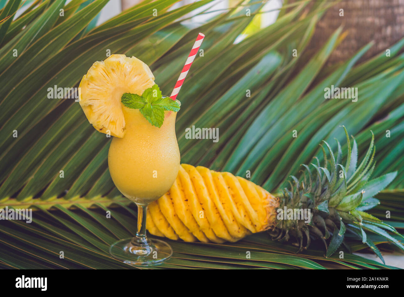 Pineapple and pineapple smoothies against the background of a branch of ...