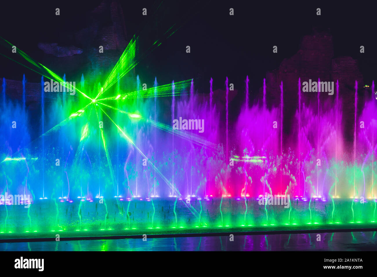 Multicolored dancing water jet fountain in the dark Stock Photo - Alamy