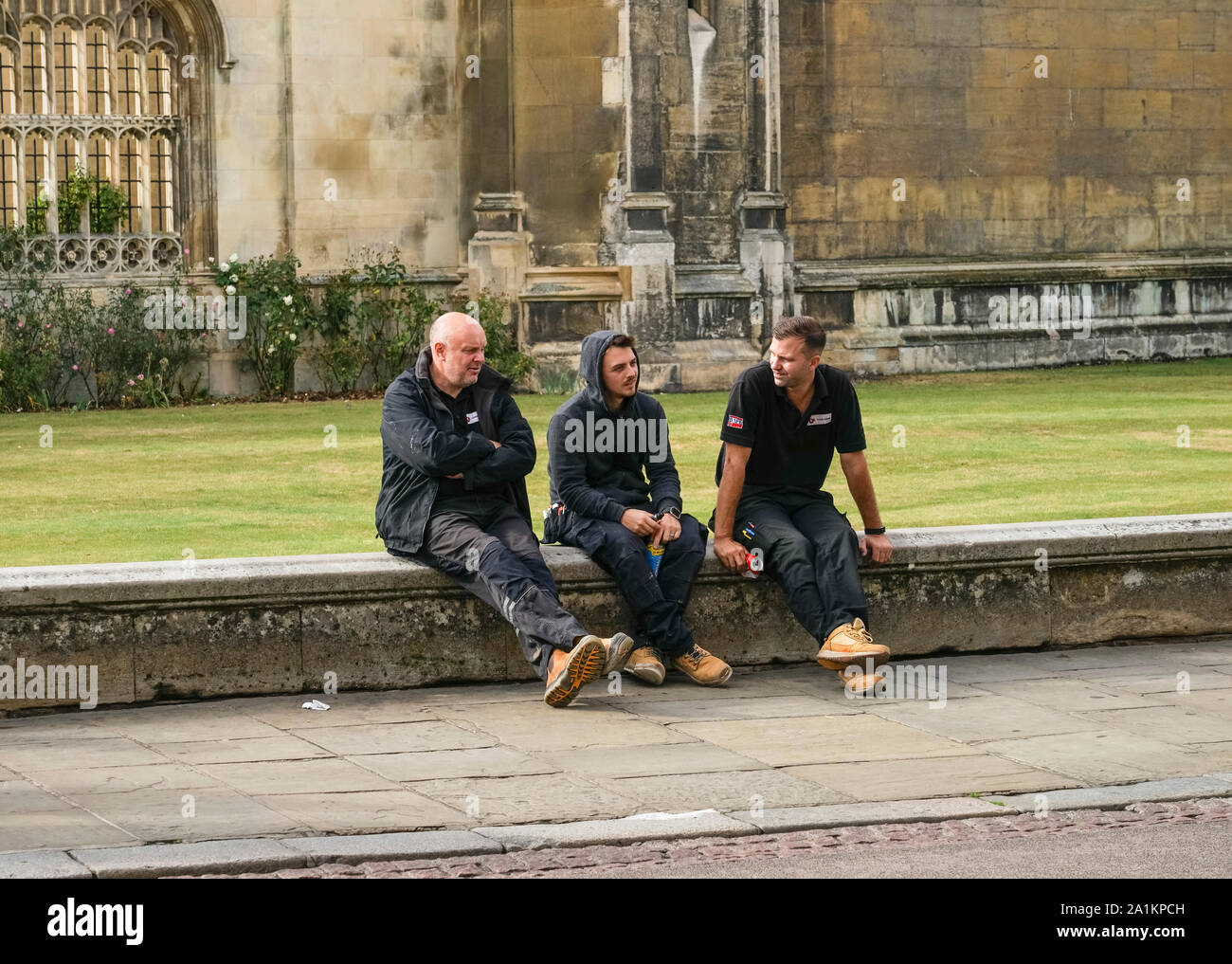 Three friends sat on wall talking hi-res stock photography and images ...