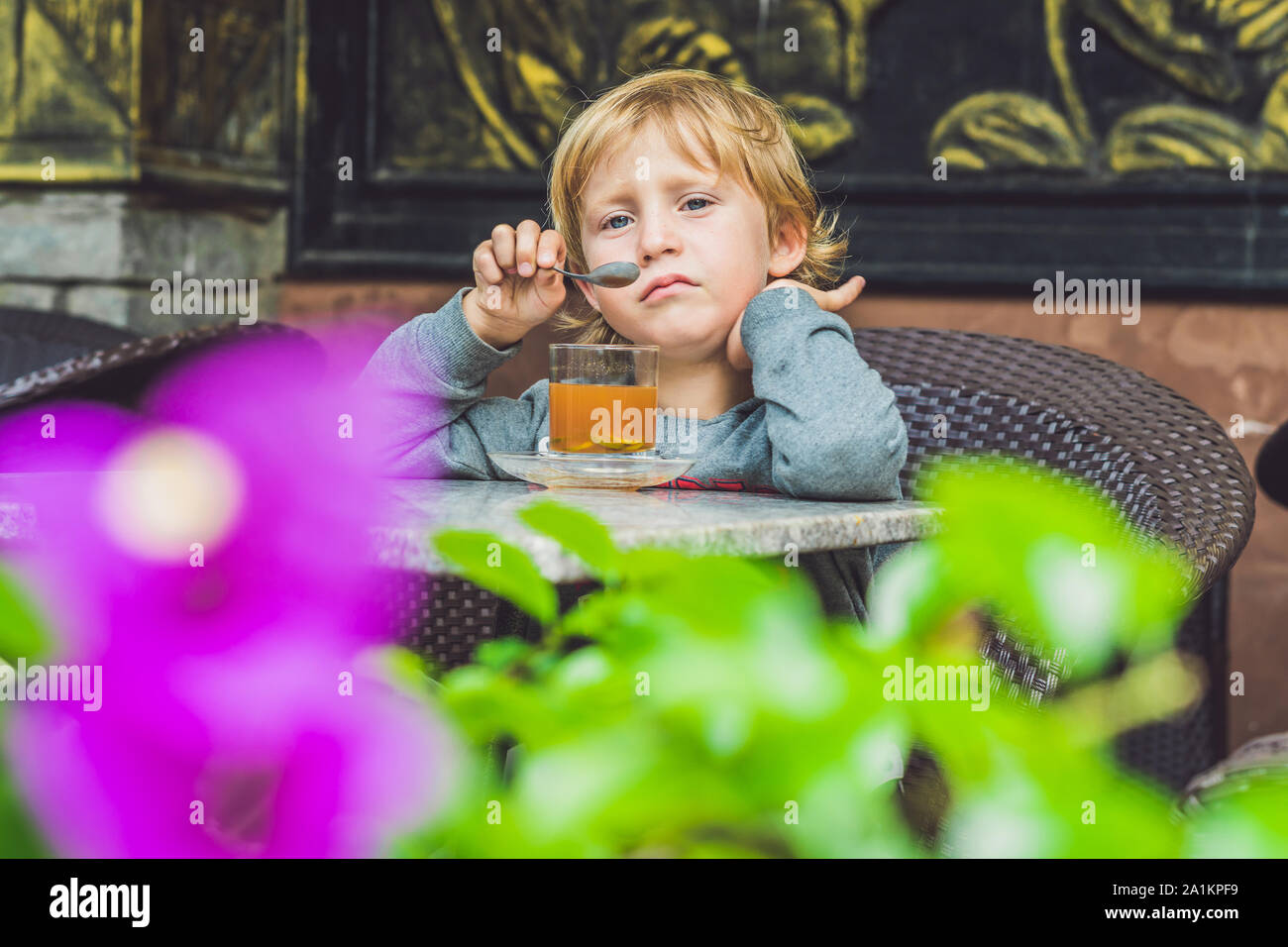 Cute little boy drinking tea in cafeteria Stock Photo - Alamy