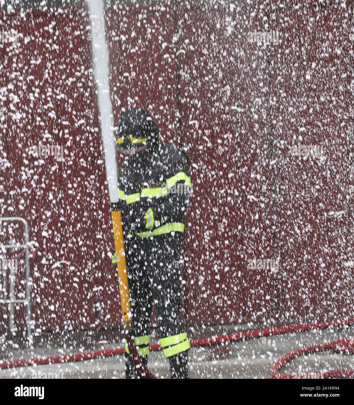 brave fire fighter with uniform uses foam like snow during fire Stock ...