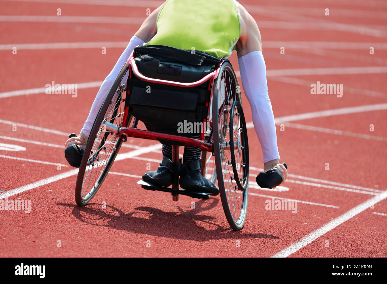 Athlete runs with wheelchair at sport venue Stock Photo - Alamy