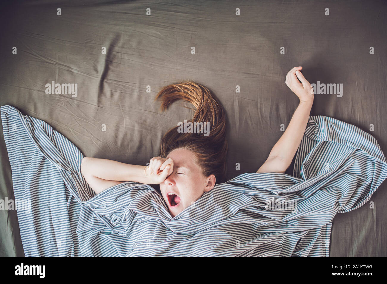 Beautiful young woman lying down in bed and sleeping, top view. Do not ...