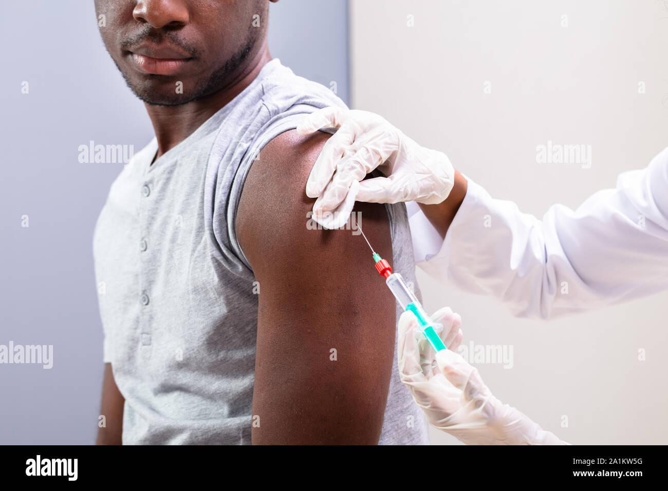 Doctor giving injection male patient hi-res stock photography and ...