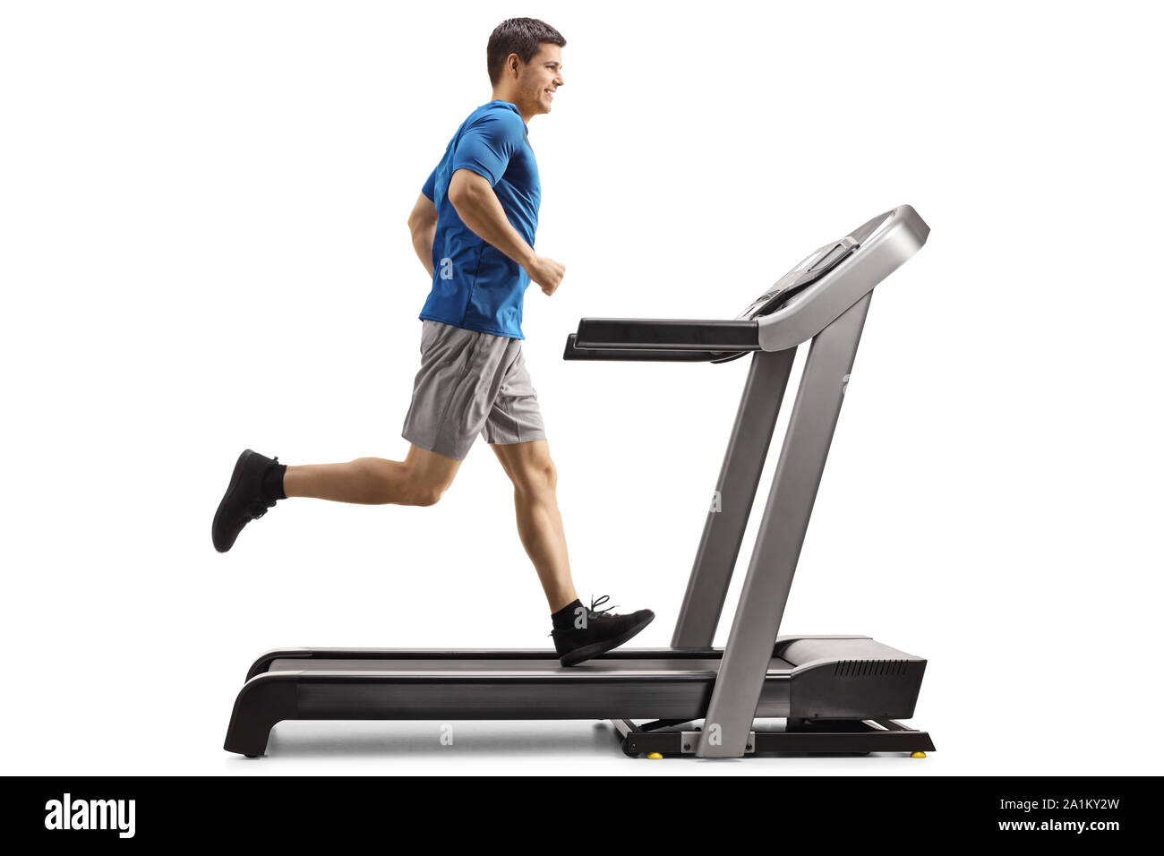 Full length profile shot of a guy running on a treadmill isolated on ...