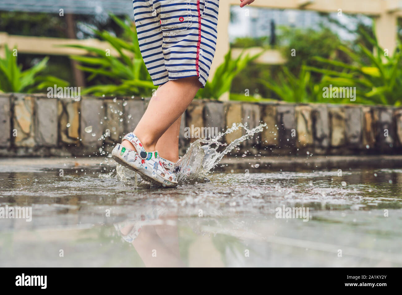 Little boy runs through a puddle. summer outdoor Stock Photo - Alamy