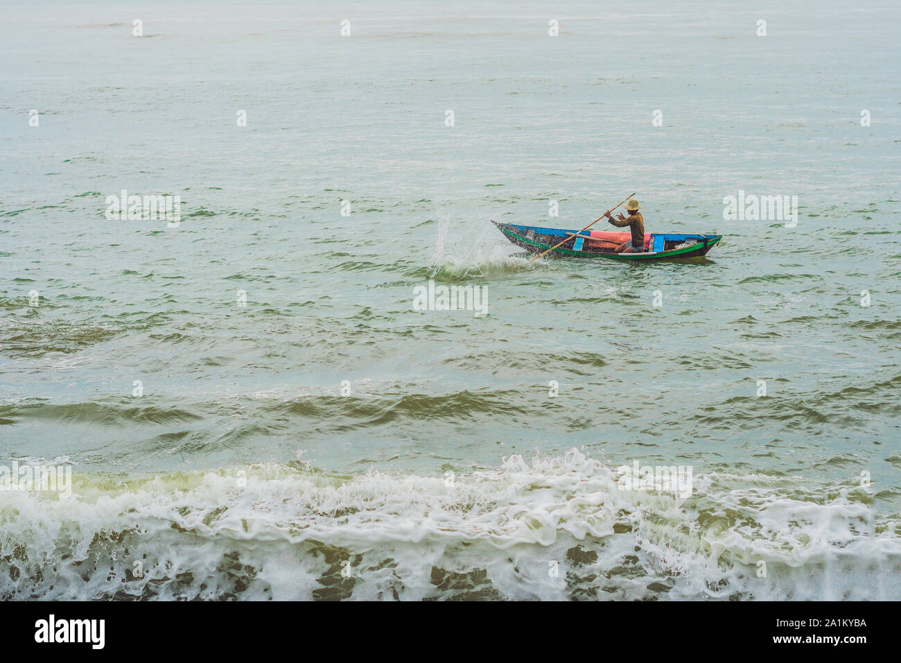 Vietnamese fisherman swims in a boat over the raging sea Stock Photo ...