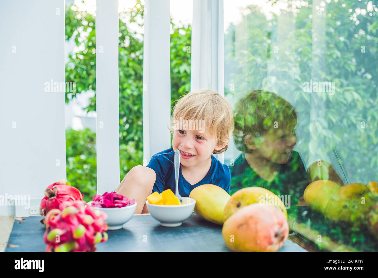 Boy eating mango hi-res stock photography and images - Alamy
