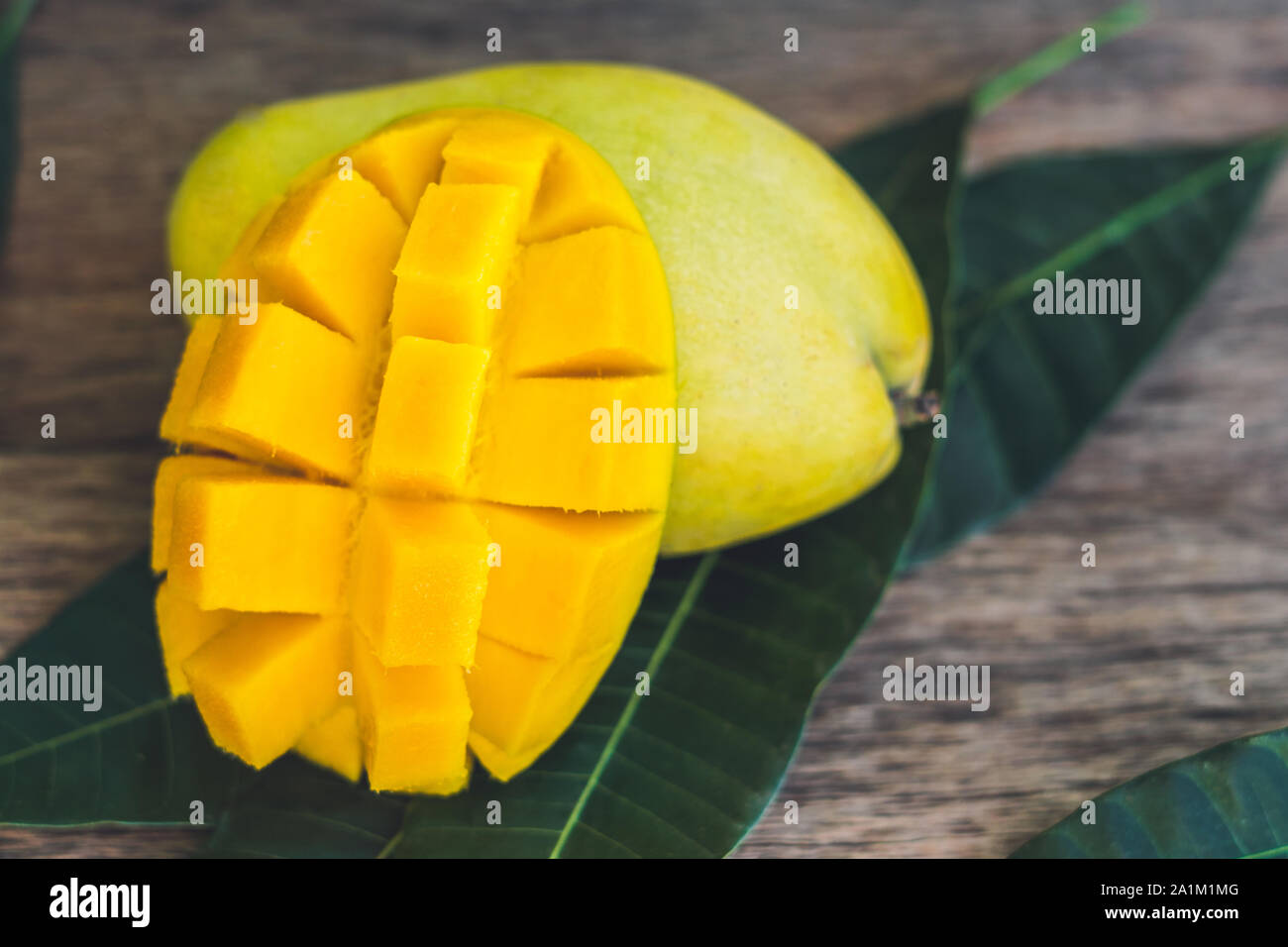 Mango and mango leaves on an old wooden background Stock Photo - Alamy