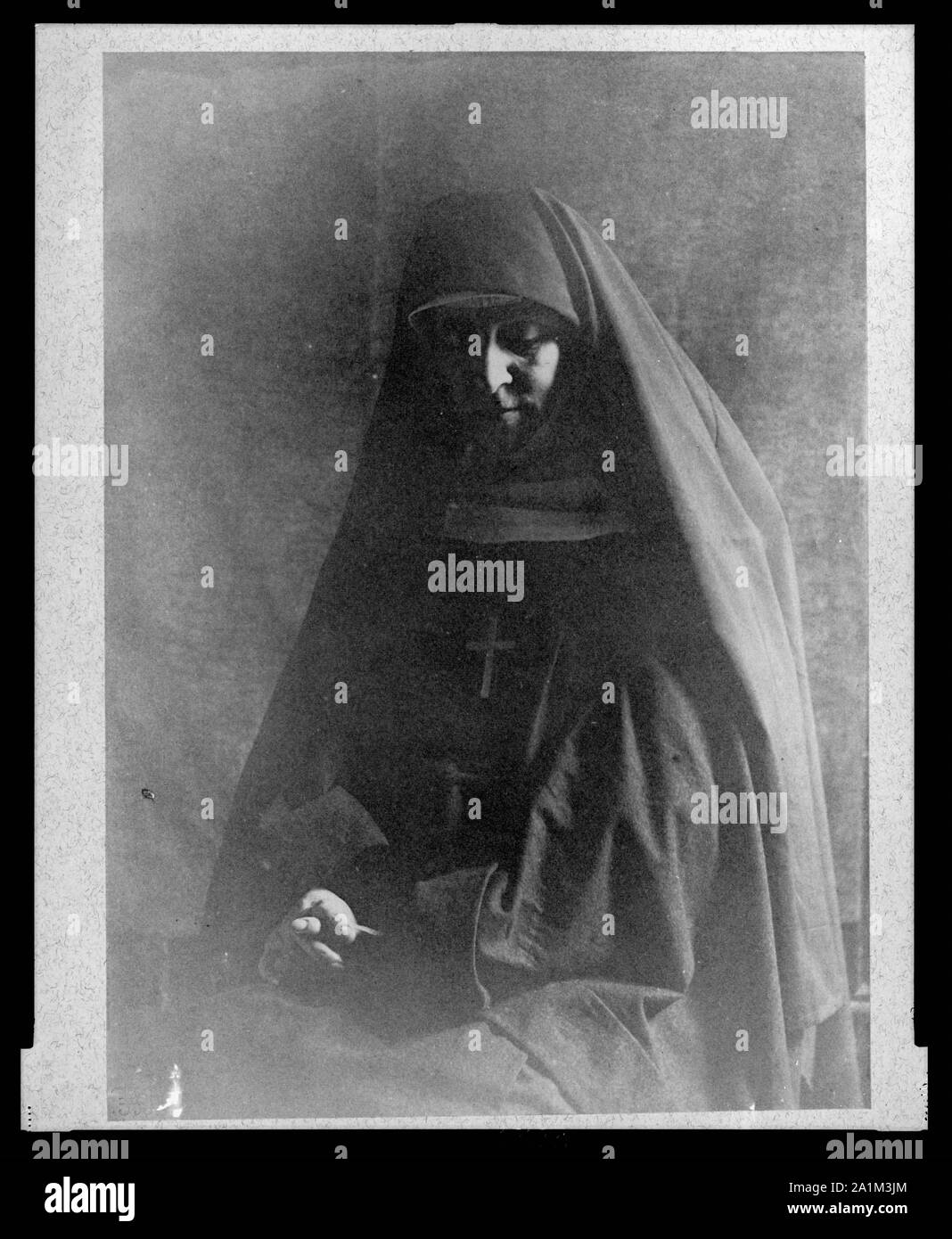 Nun with hands folded, praying, seated Stock Photo - Alamy