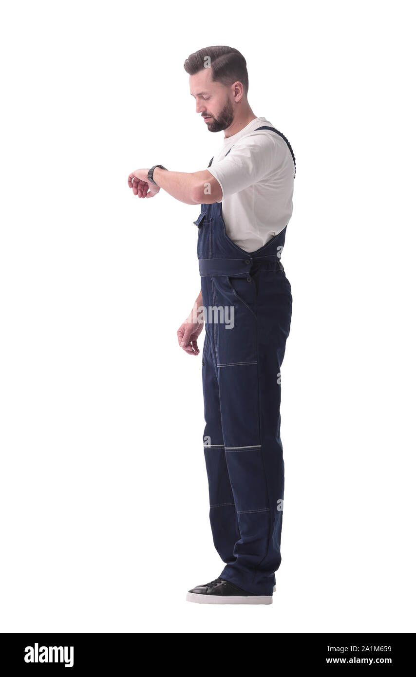side view. a man in overalls looking at his wristwatch Stock Photo - Alamy