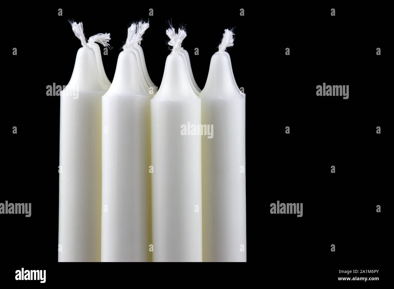 White candles isolated on a black background Stock Photo - Alamy