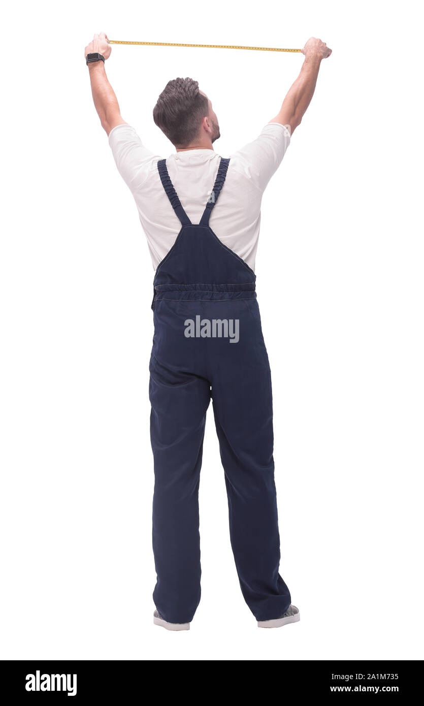 rear view. a man measuring something with a construction tape measure ...