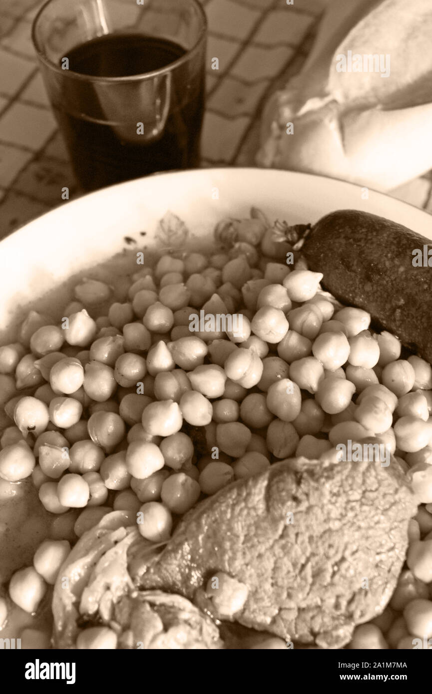 Chickpeas cooked with blood sausage, meat, bacon. Homemade bread. Red ...