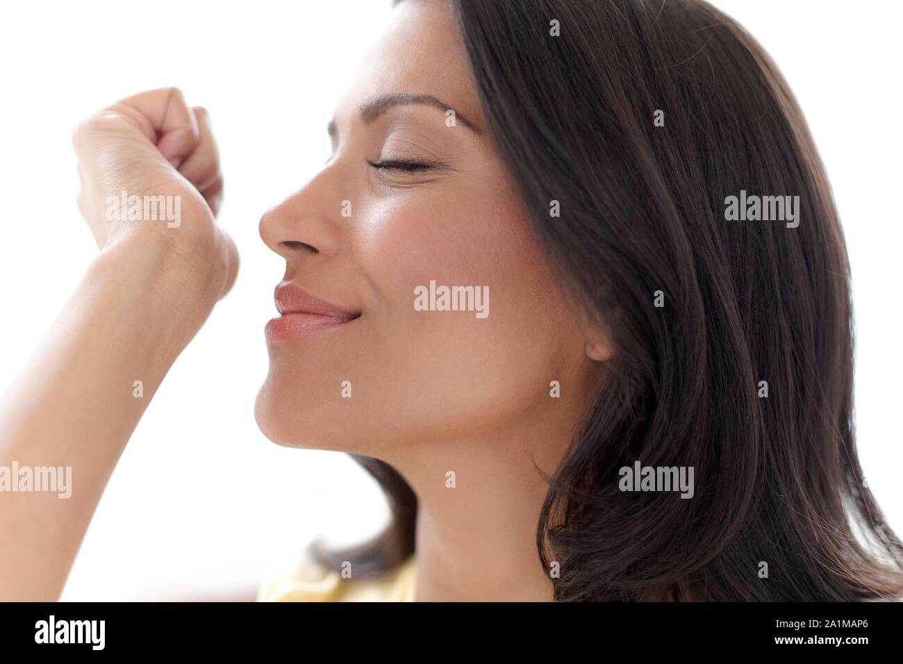 Woman smelling perfume on her wrist Stock Photo - Alamy