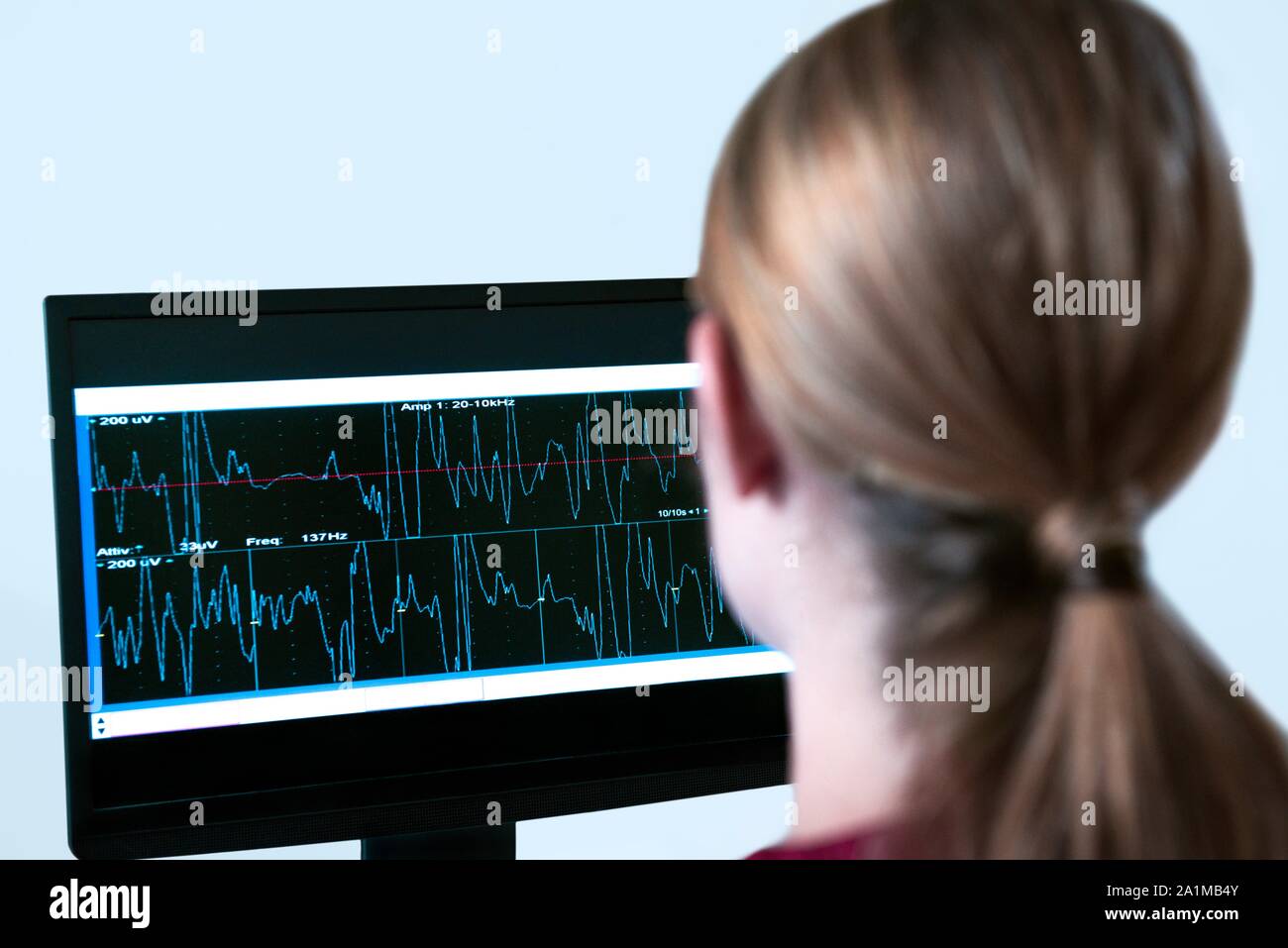 Female medical professional looking at EMG (electromyography) results ...