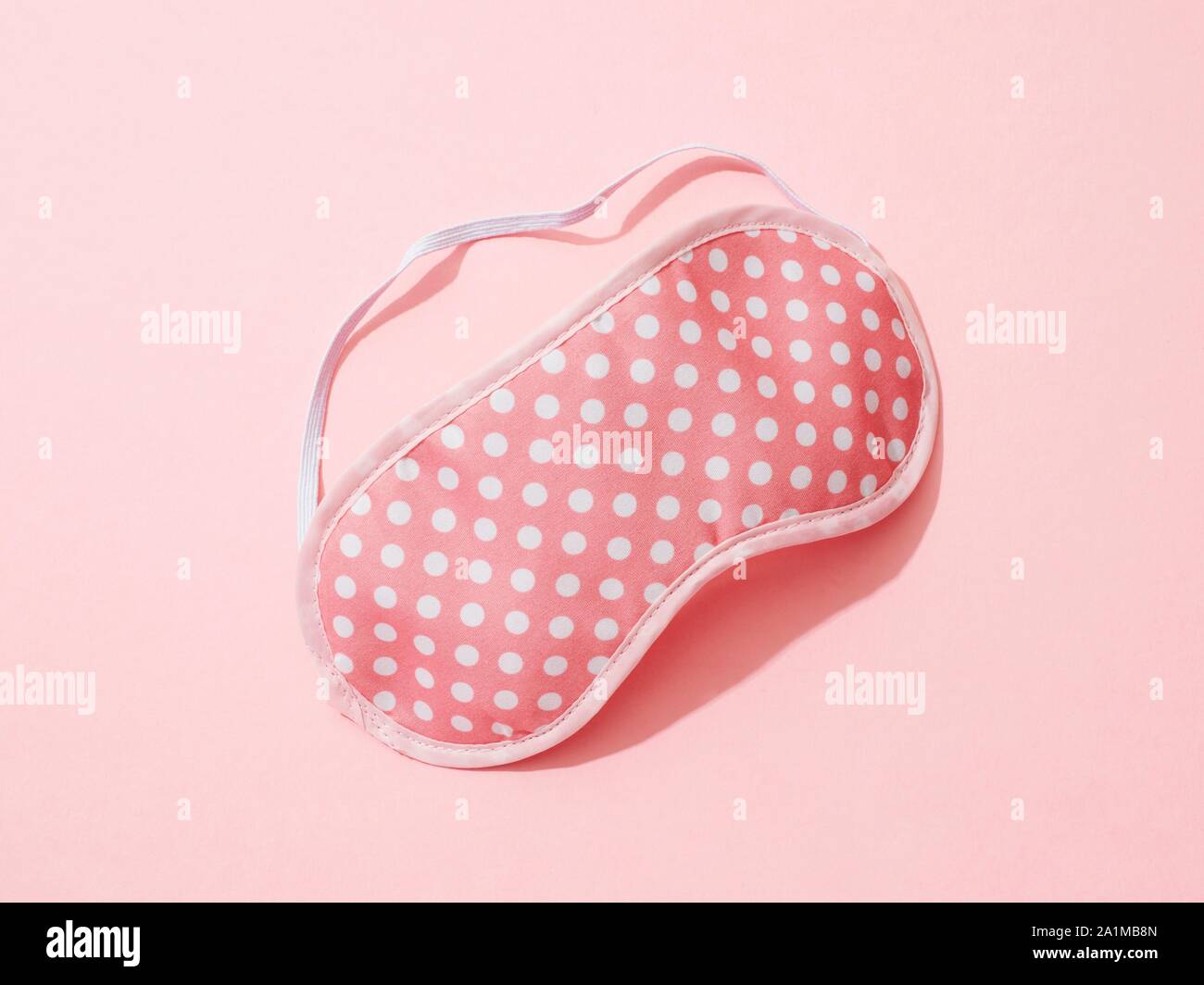 Sleep mask on pink background Stock Photo - Alamy