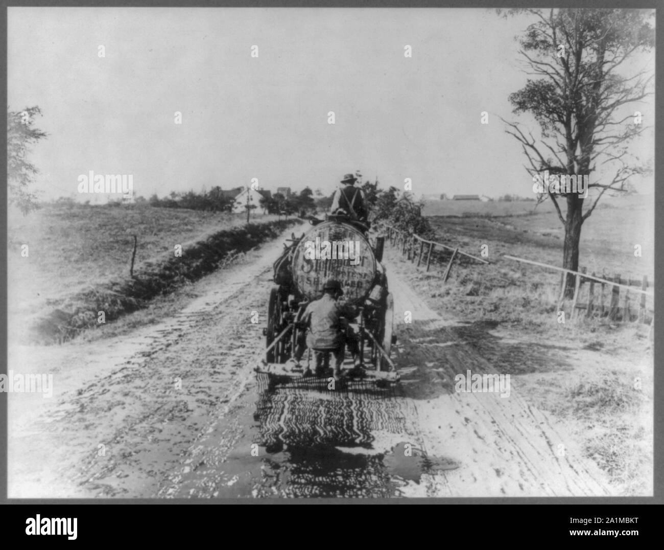 Oil distributer at work [spreading oil on dirt road] Stock Photo - Alamy