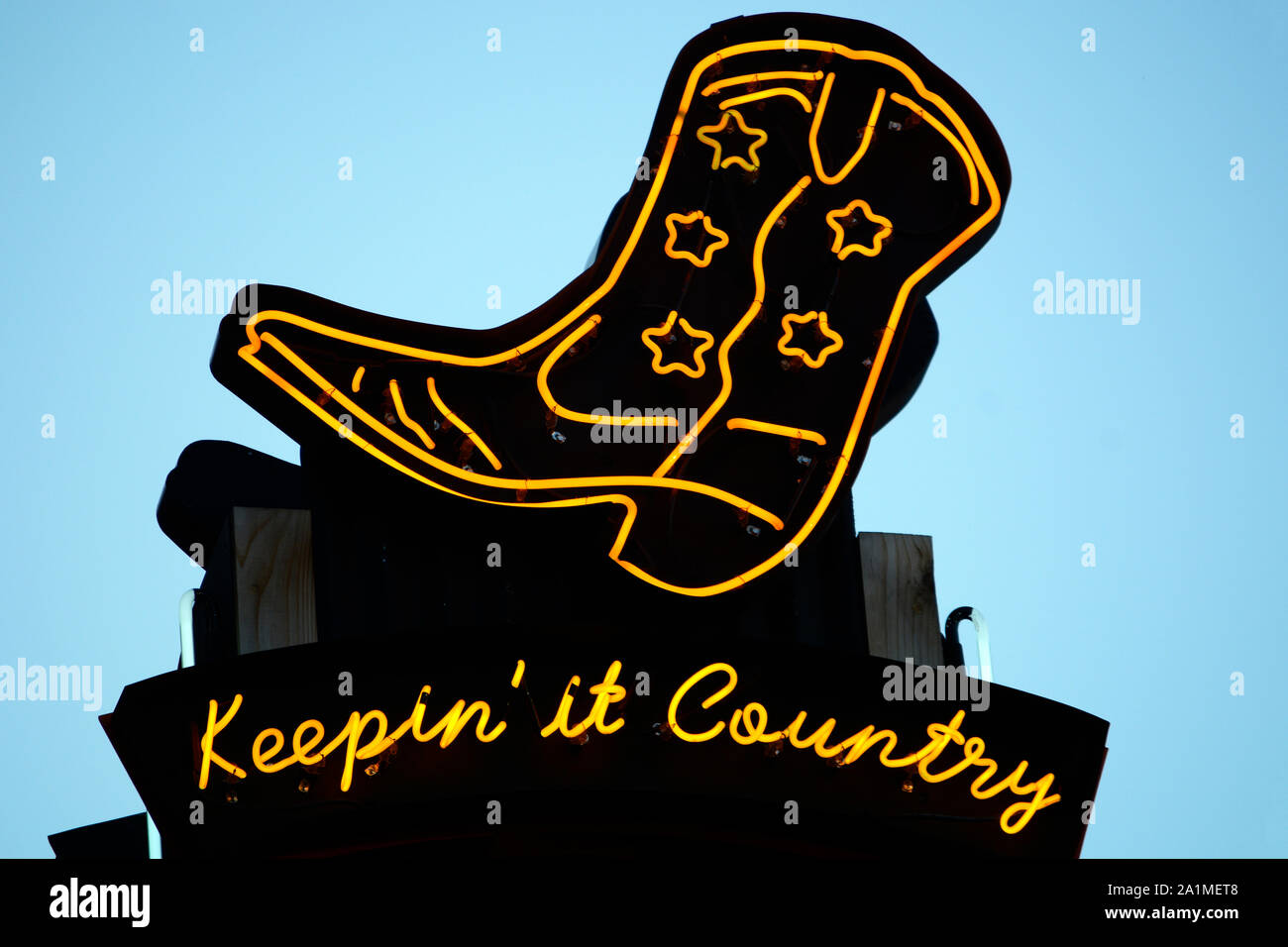 A country music bar's neon sign includes a cowboy boot in Nashville ...