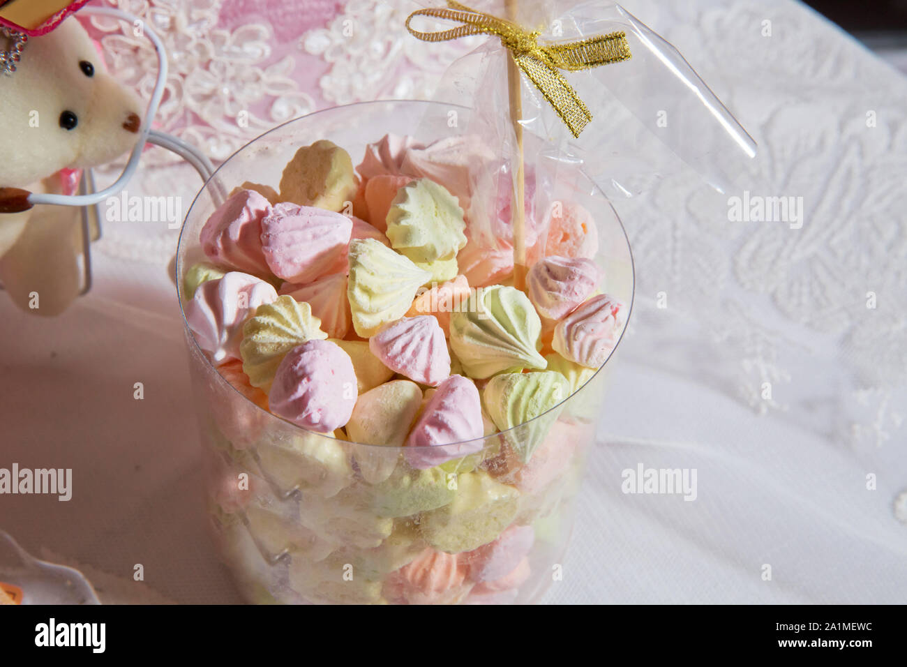 colorful marshmallow candies in plastic container on a white background ...