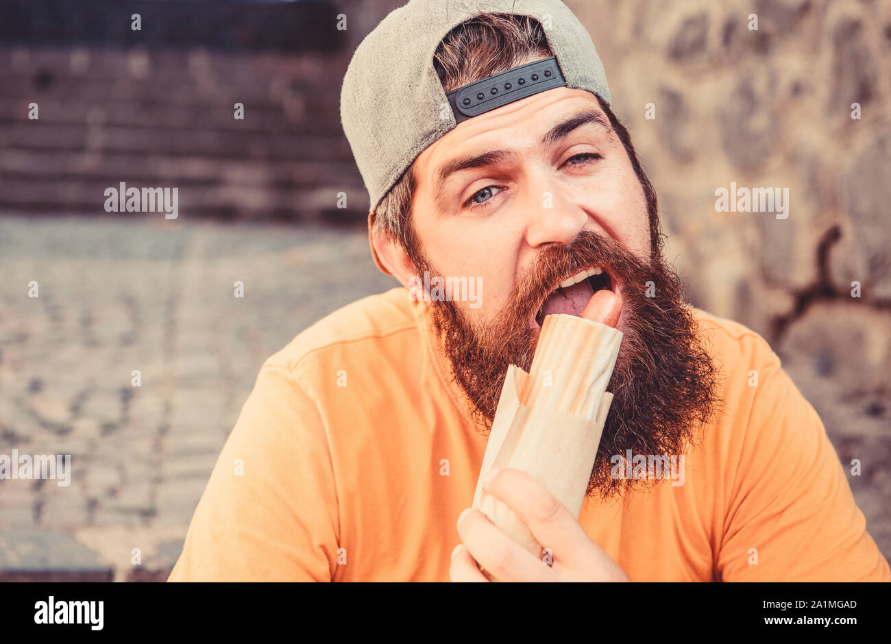 Hungry man snack. Junk food. Guy eating hot dog. Man bearded bite tasty ...