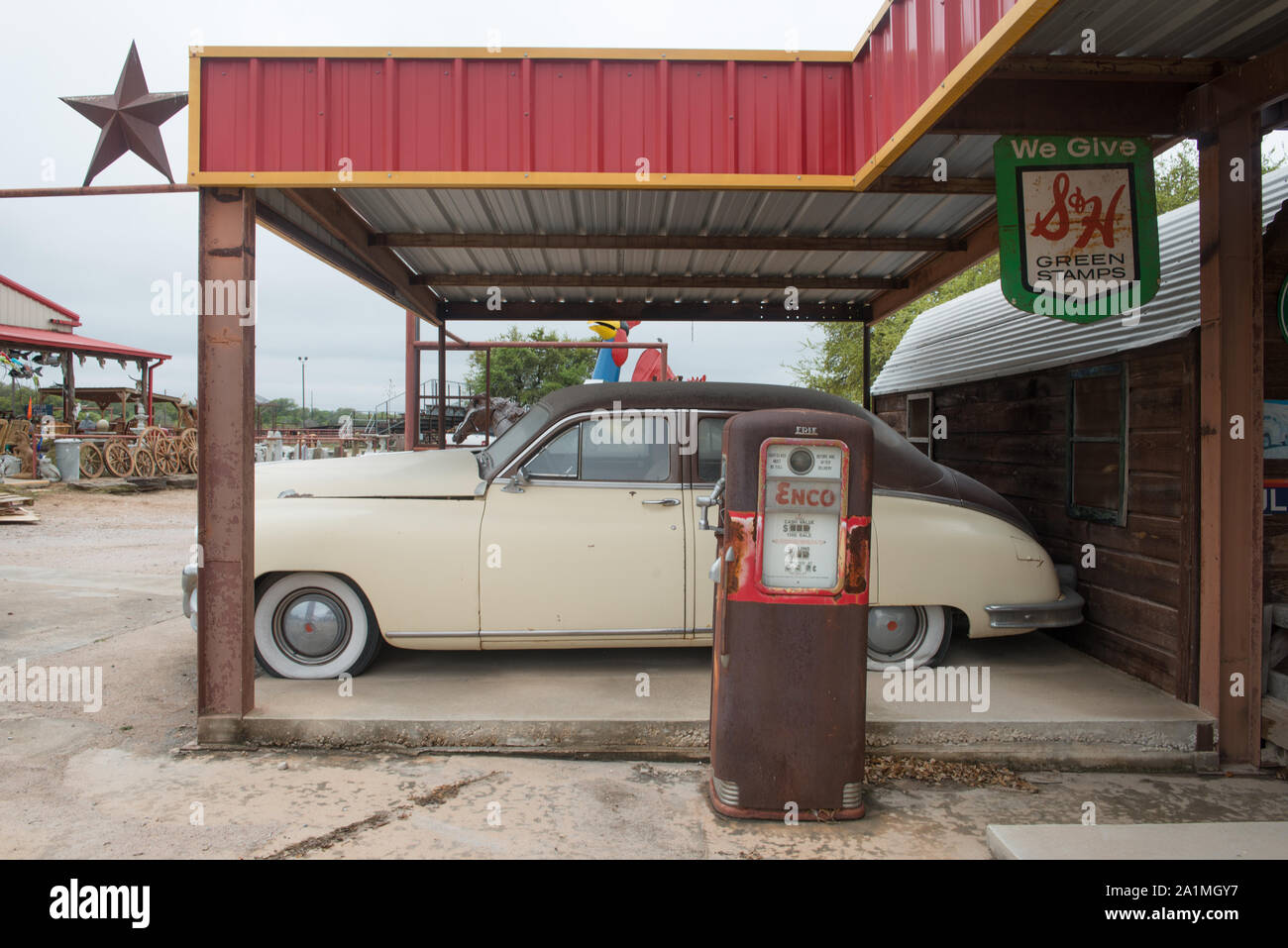 Old cars beneath an awning at a re-created Shell gasoline station at ...