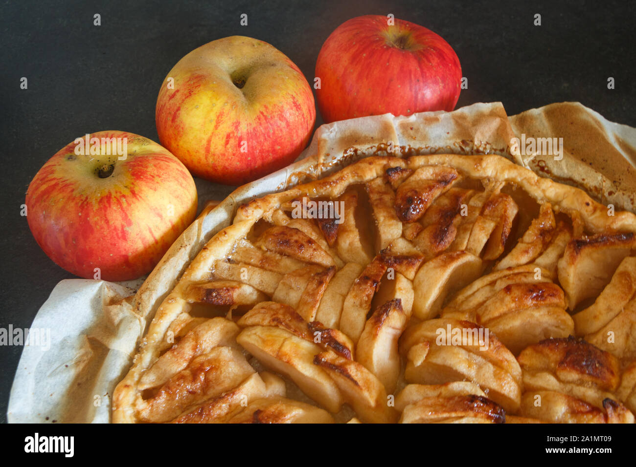 Homemade apple tart on a dish and three apples Stock Photo - Alamy