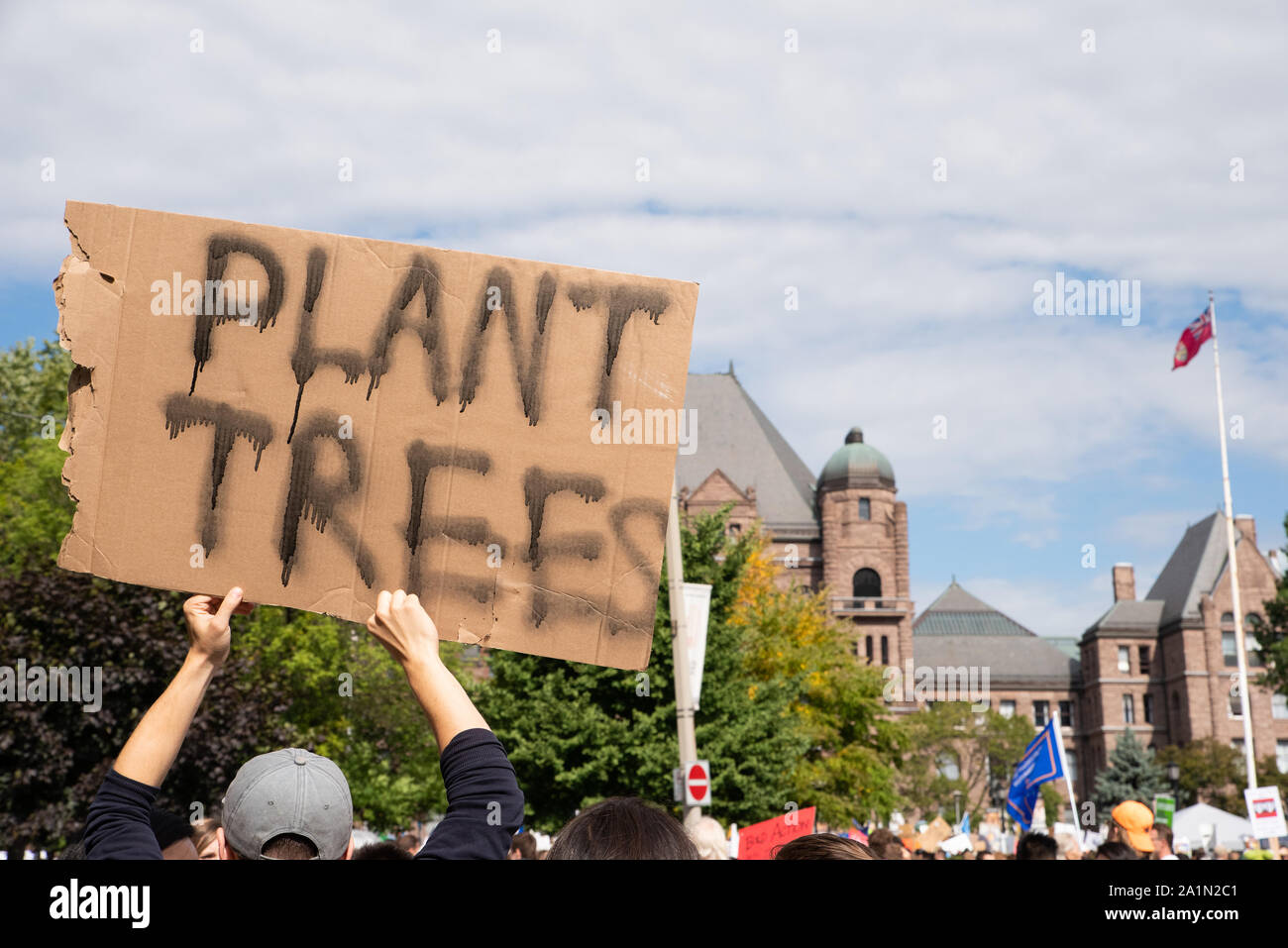 A demonstrator waves a sign promoting reforestation outside the Ontario ...
