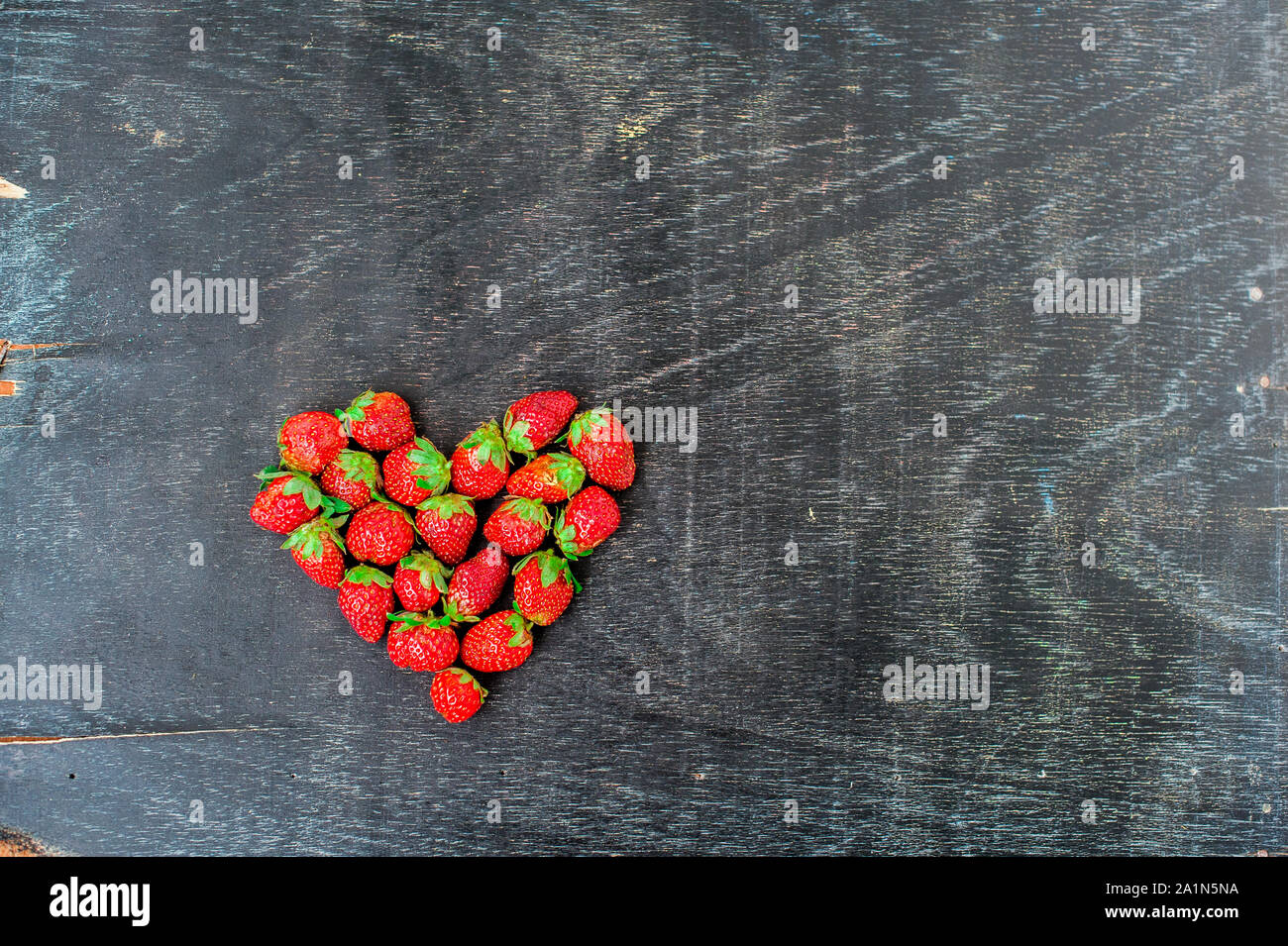 Fresh strawberries array heart shape on old wooden background Stock ...