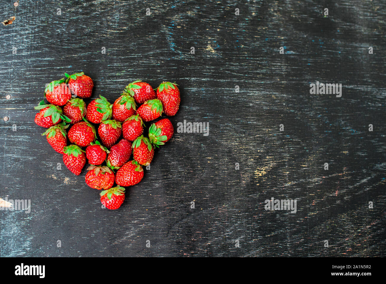 Fresh strawberries array heart shape on old wooden background Stock ...