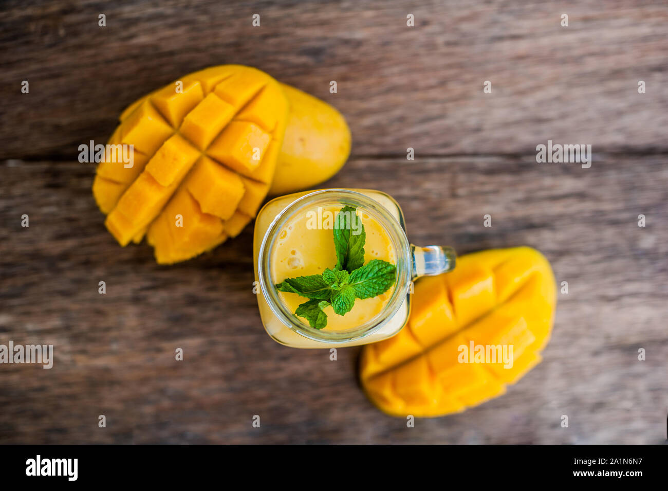 Mango smoothie in a glass Mason jar and mango on the old wooden ...