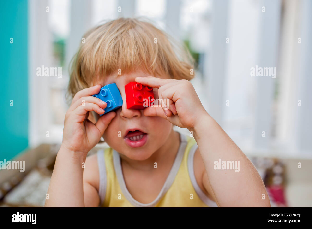 The boy makes eyes of colorful children's blocks. Cute little kid boy ...
