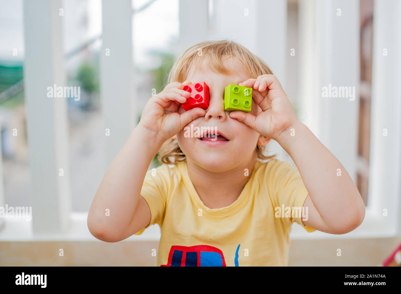 The boy makes eyes of colorful children's blocks. Cute little kid boy ...