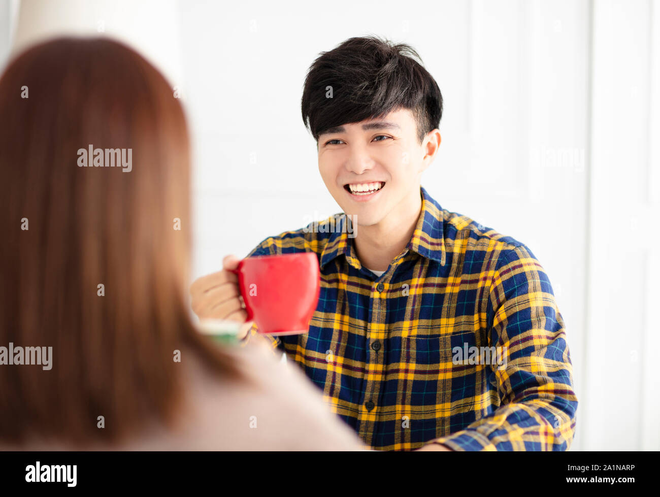 Happy young couple talking and laughing, drinking tea Stock Photo - Alamy